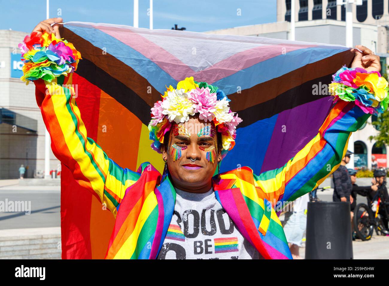 Young asian man celebrating Pride in vibrant rainbow suit & umbrella ...