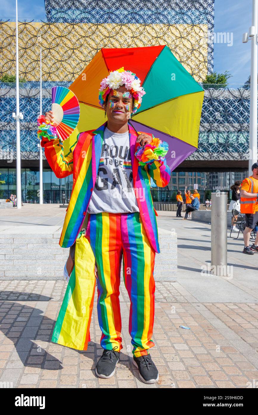 Young asian man celebrating Pride in vibrant rainbow suit & umbrella ...