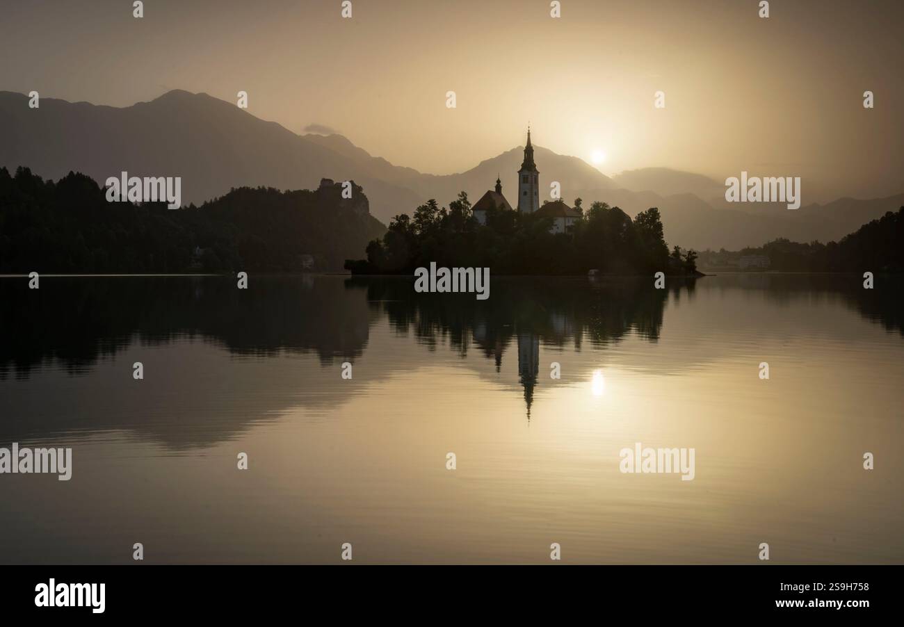 Lake Bled during golden hour sunrise with reflections Stock Photo - Alamy