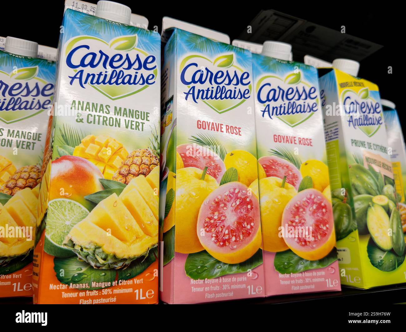Tropical fruit juice boxes lined on a supermarket shelf in summer ...