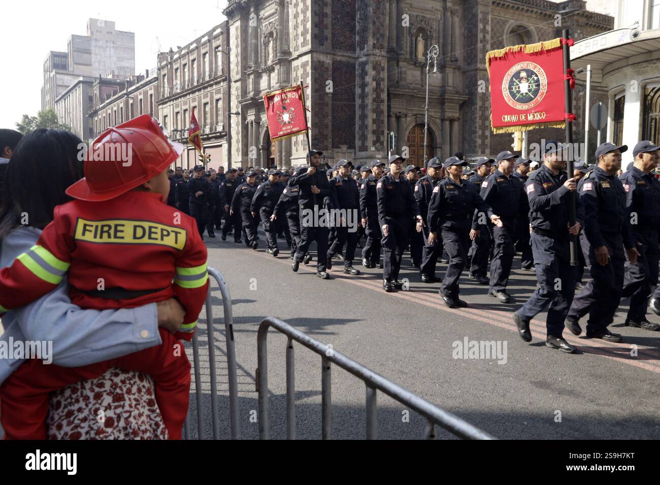 Non Exclusive: A woman with her son dressed as a firefighter watch the ...