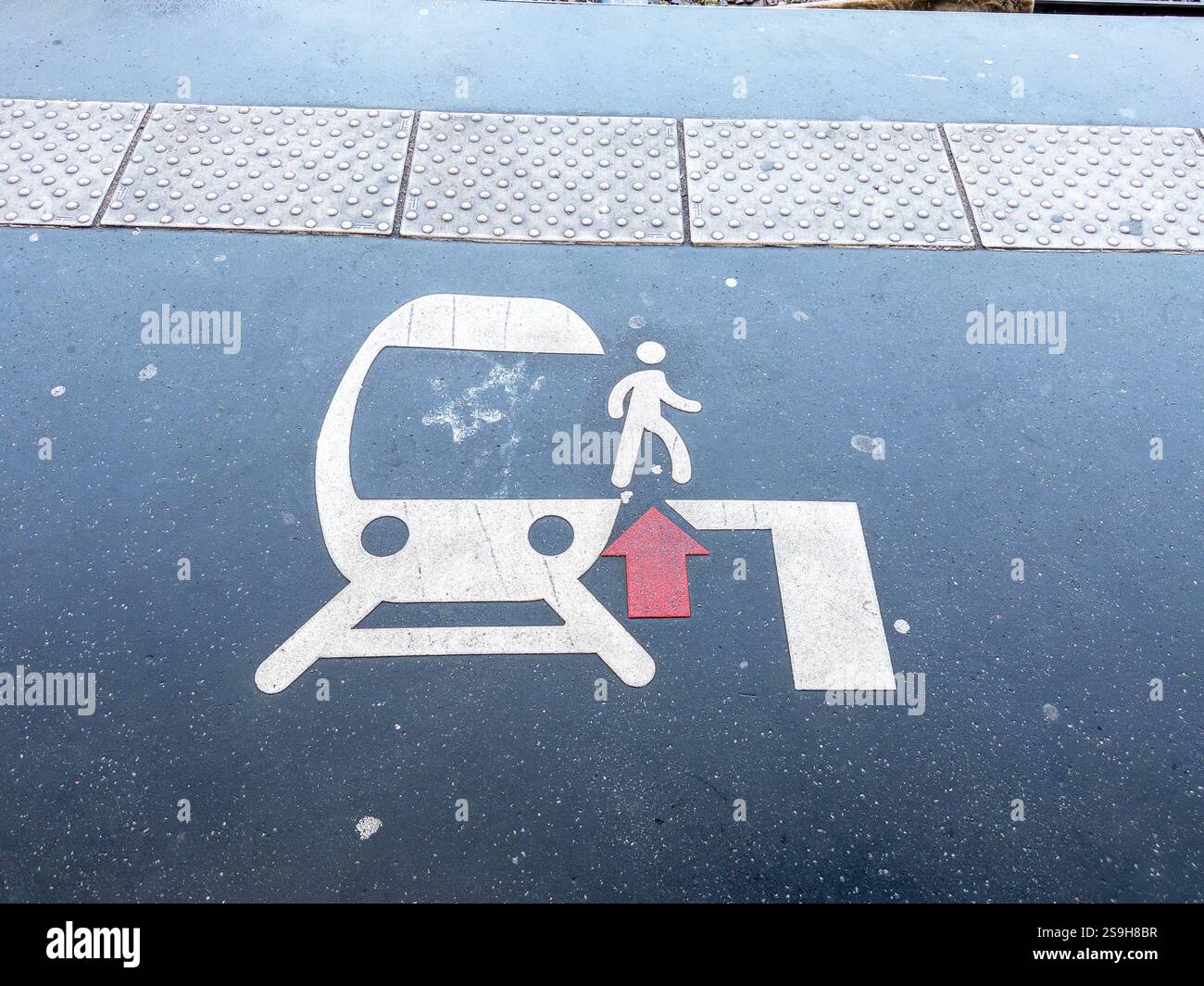 Warning icon signaling safe boarding at a busy train station platform ...