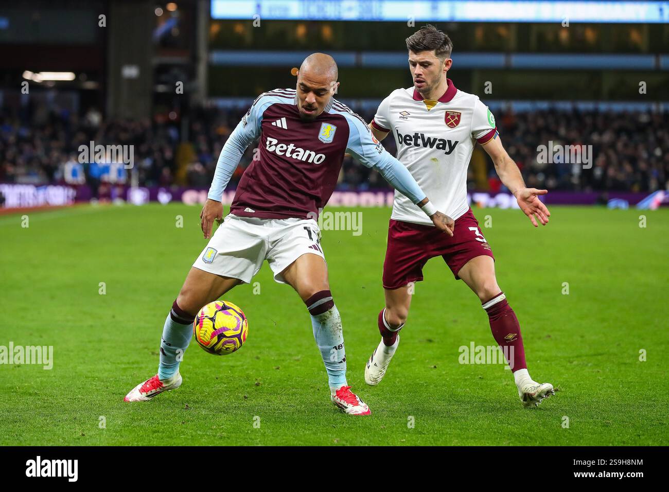 Donyell Malen of Aston Villa holds off Aaron Cresswell of West Ham ...