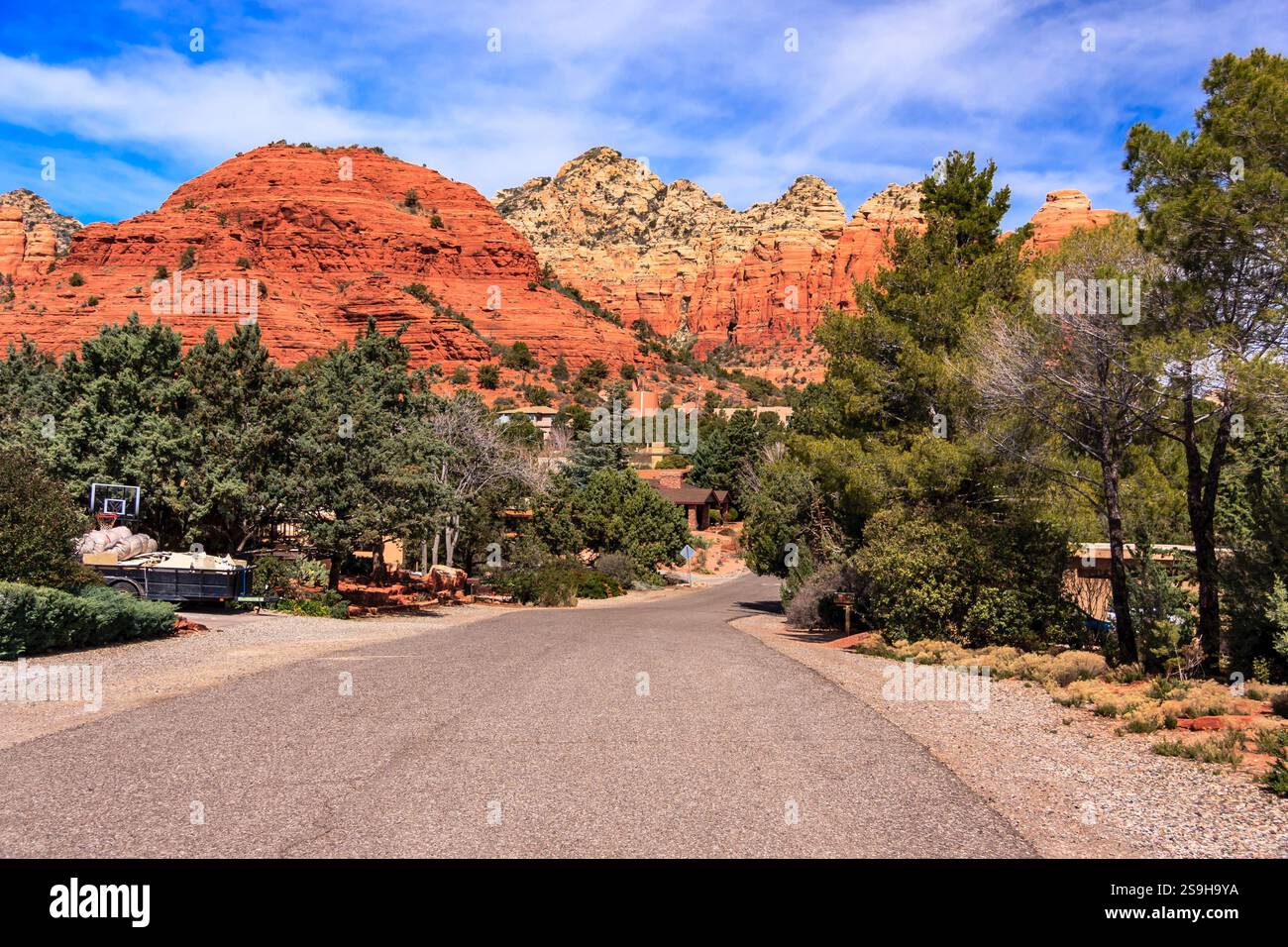 A road in the desert with a house on the side. The road is empty and ...
