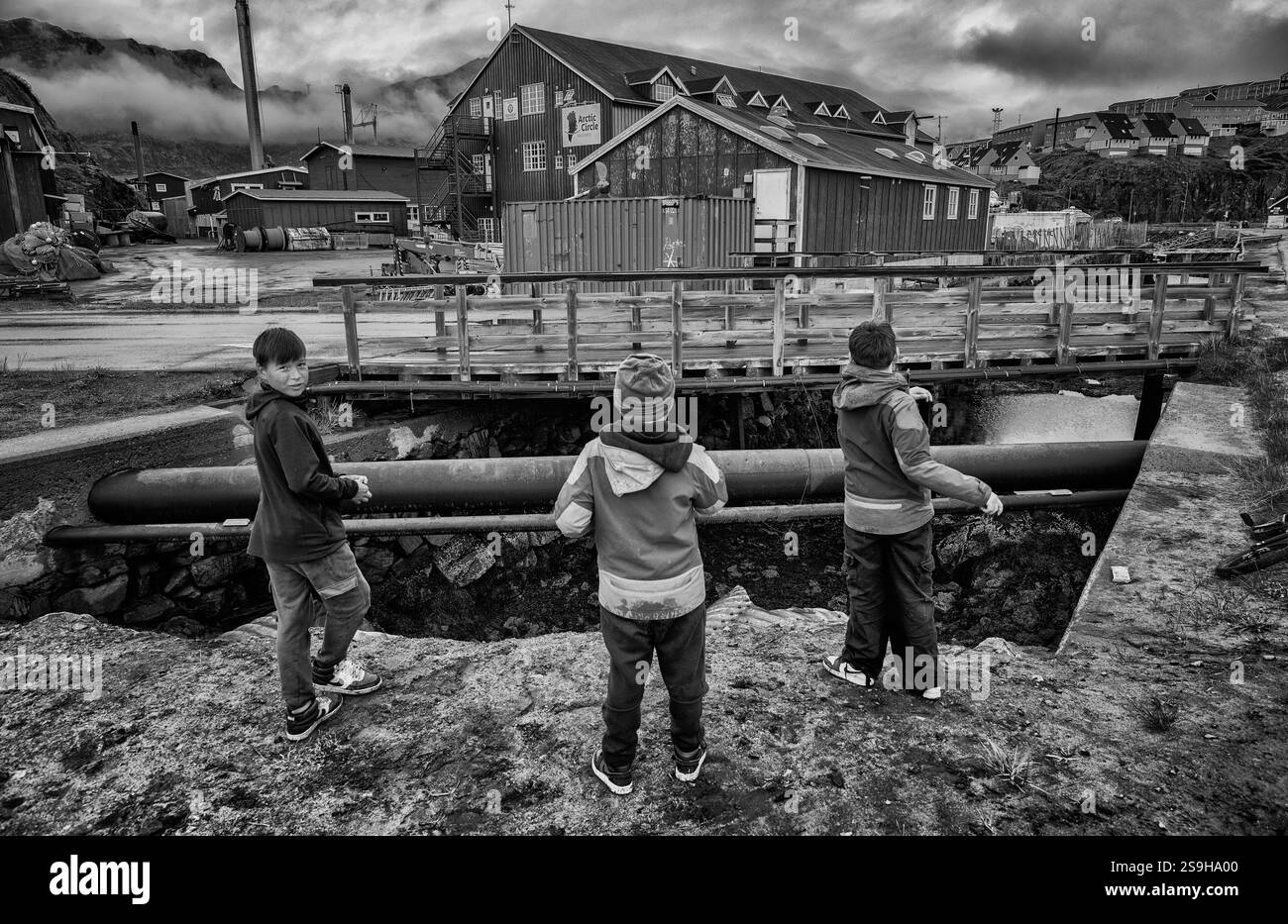 Three Inuit children interact with their surroundings in Sisimiut ...