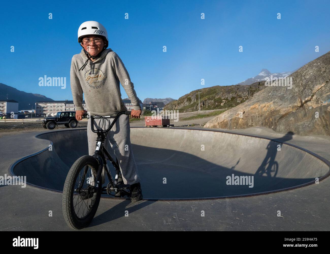 A young Inuit boy rides his BMX bike at a local skatepark in Sisimiut ...