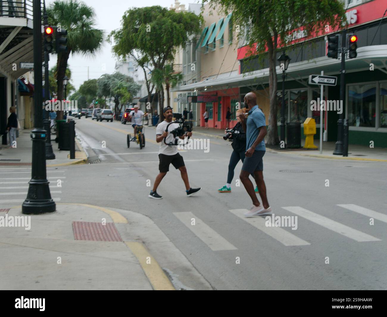 Small three person film crew, video camera man, woman taking pictures ...