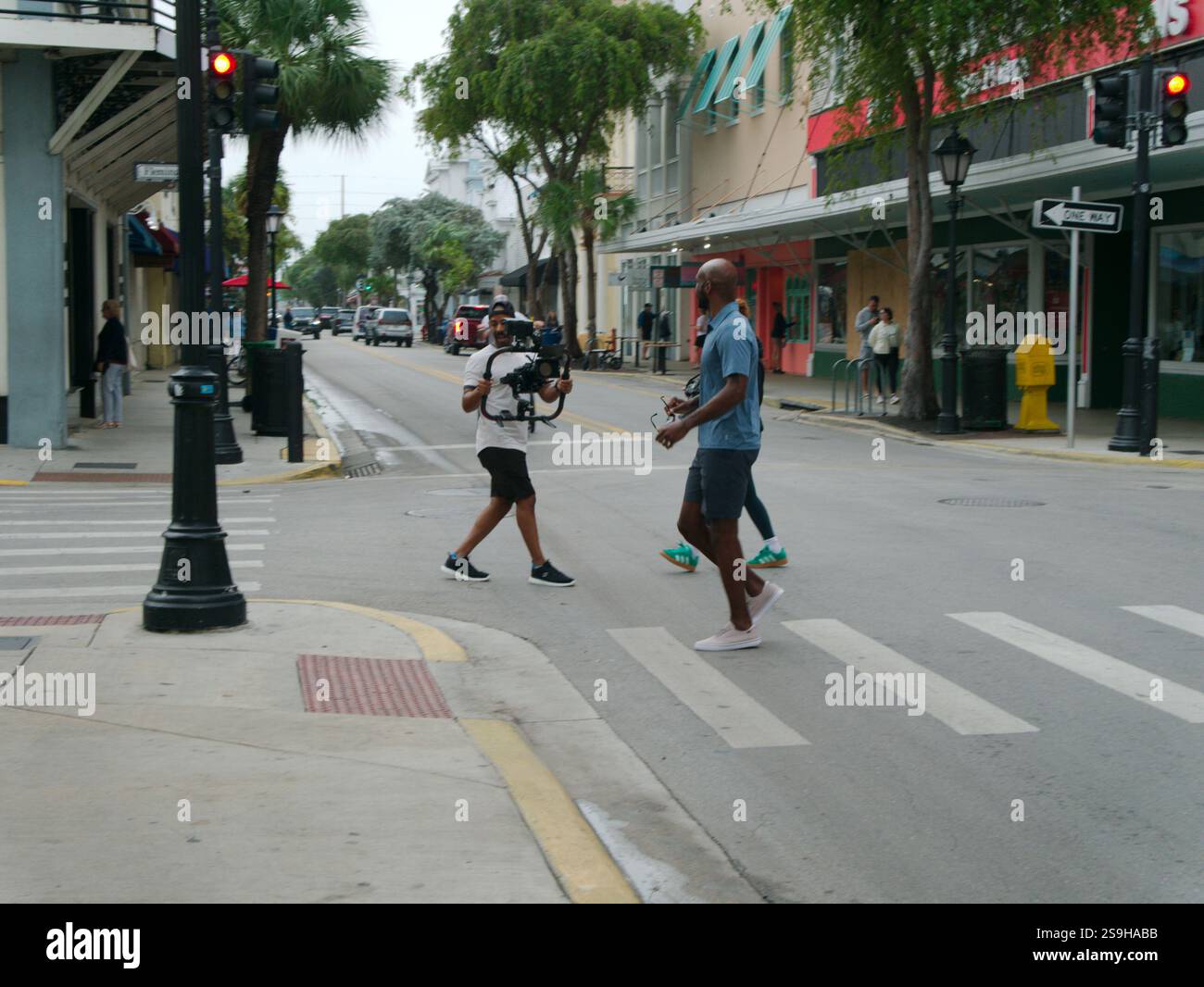 Small three person film crew, video camera man, woman taking pictures ...