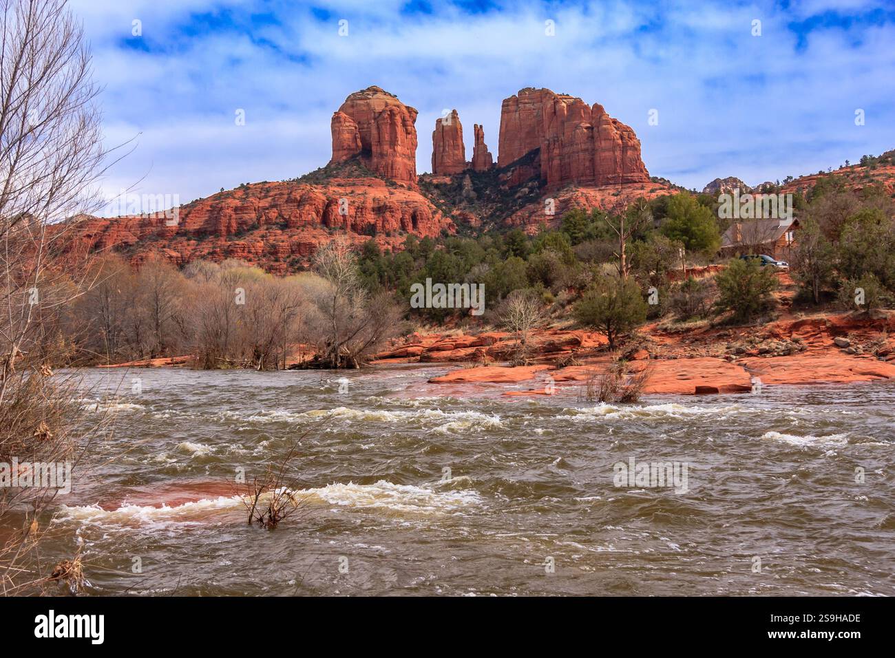 A river with a rocky shoreline and a mountain in the background. The ...