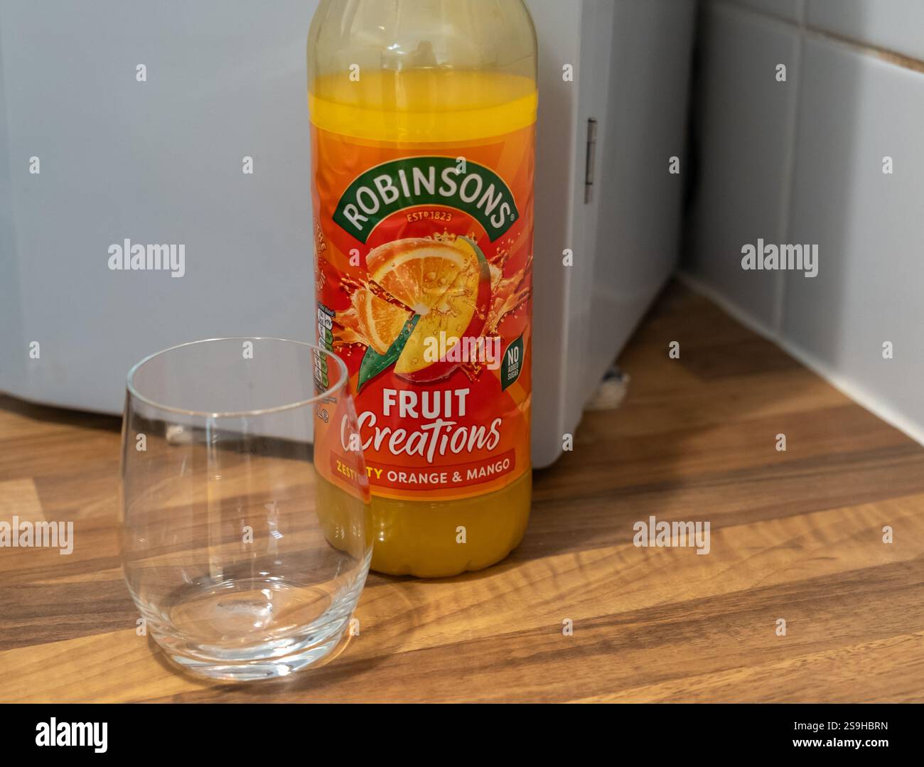 Bottle of orange and mango squash and empty glass Stock Photo - Alamy
