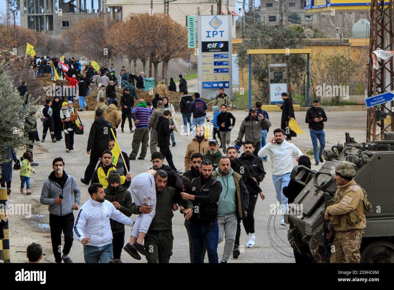 26 January 2025, Lebanon, Kfarkela: A man carries a wounded person, who ...