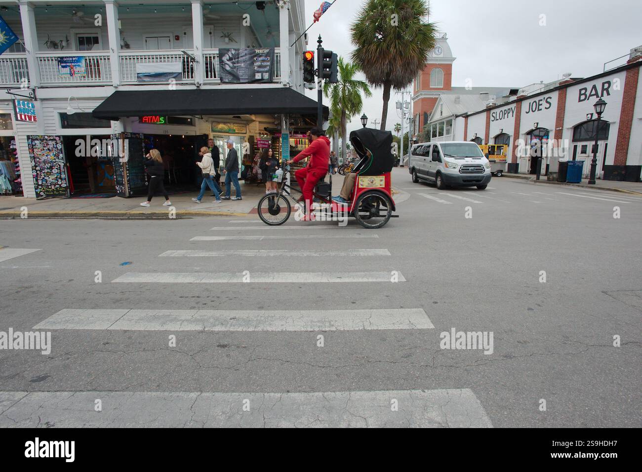 View across crosswalk towards red Bicycle Taxi pedal cycle rickshaw ...