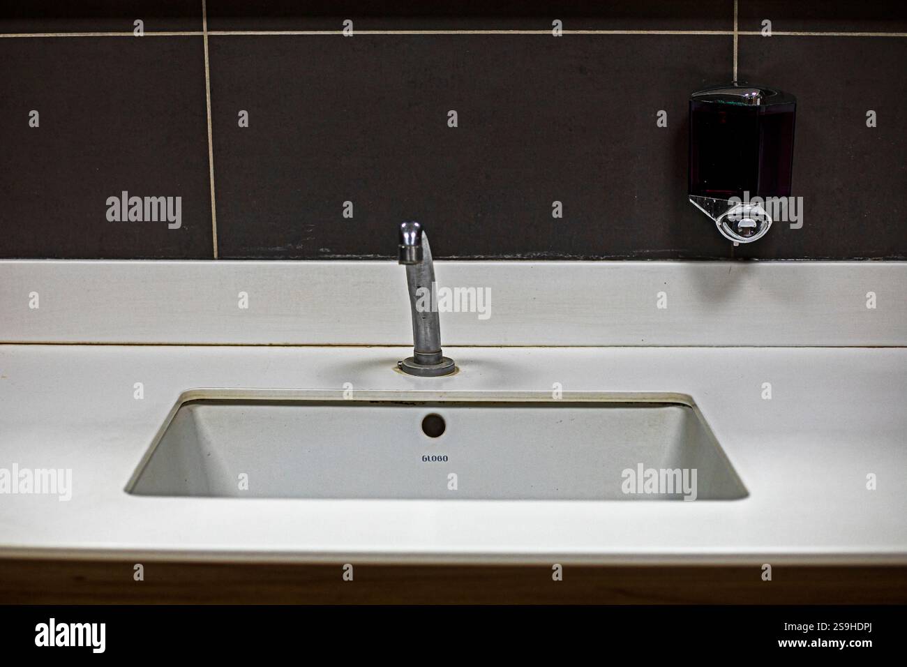 stylish sink and faucet in a dark interior with a frontal mirror. Style ...
