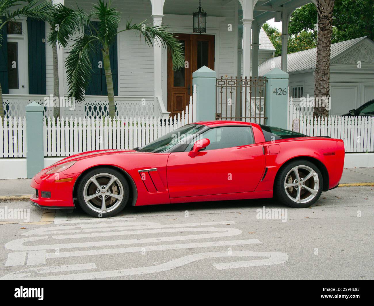 Red Chevrolet Corvette parked on side of the street view. White House ...