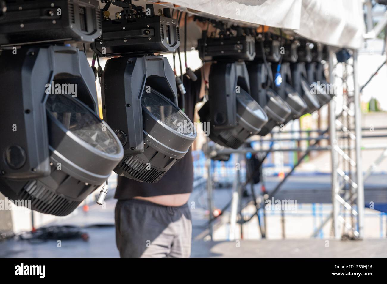 Installation of lighting equipment on a mobile concert stage. A worker ...