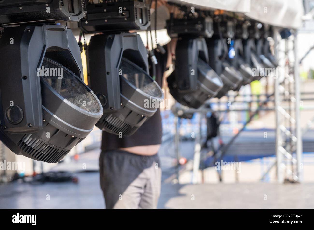 Installation of lighting equipment on a mobile concert stage. A worker ...