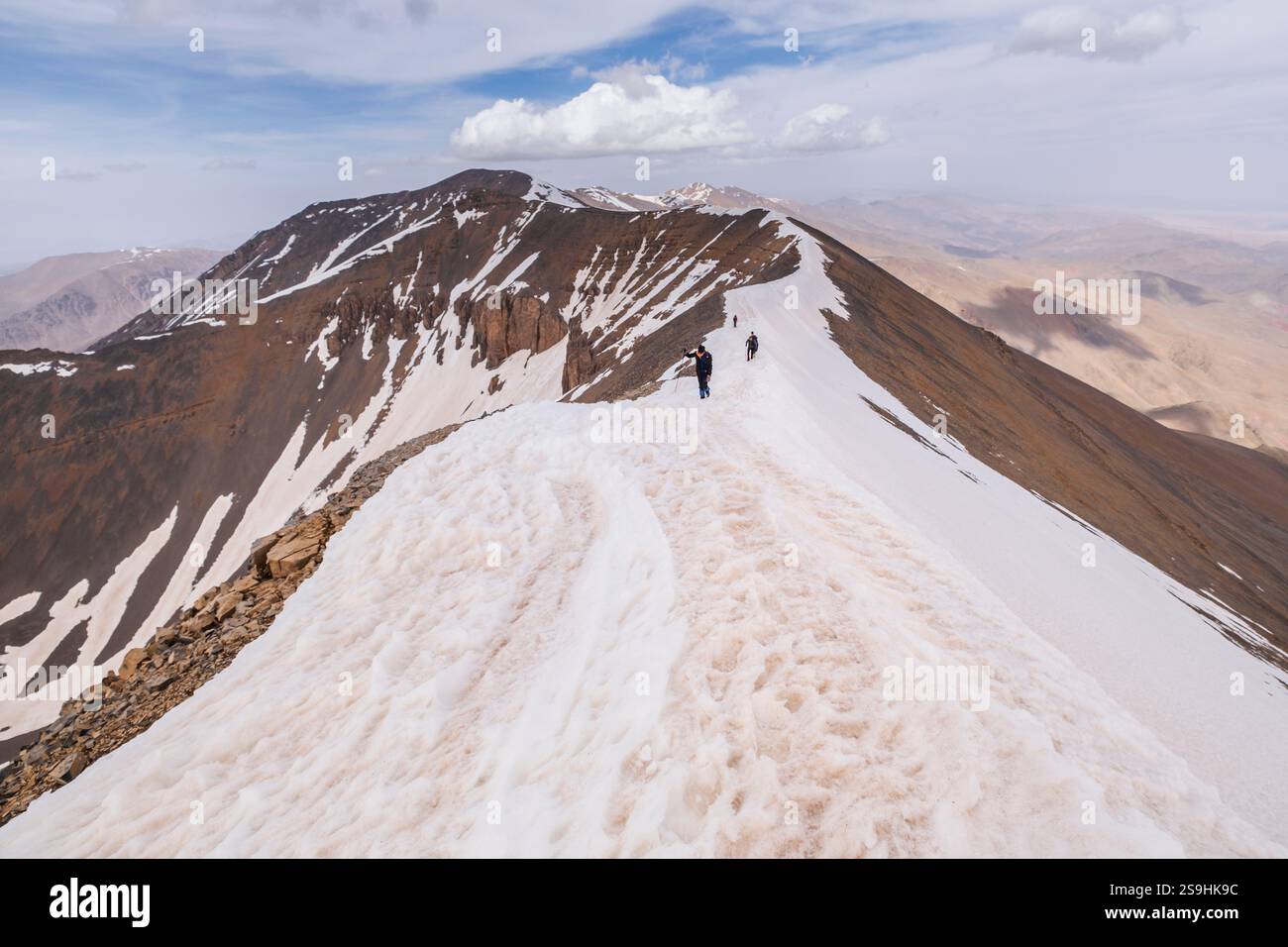 mountaineers on the ridge reaching the top Ighil M'Goun, 4,071 meters ...