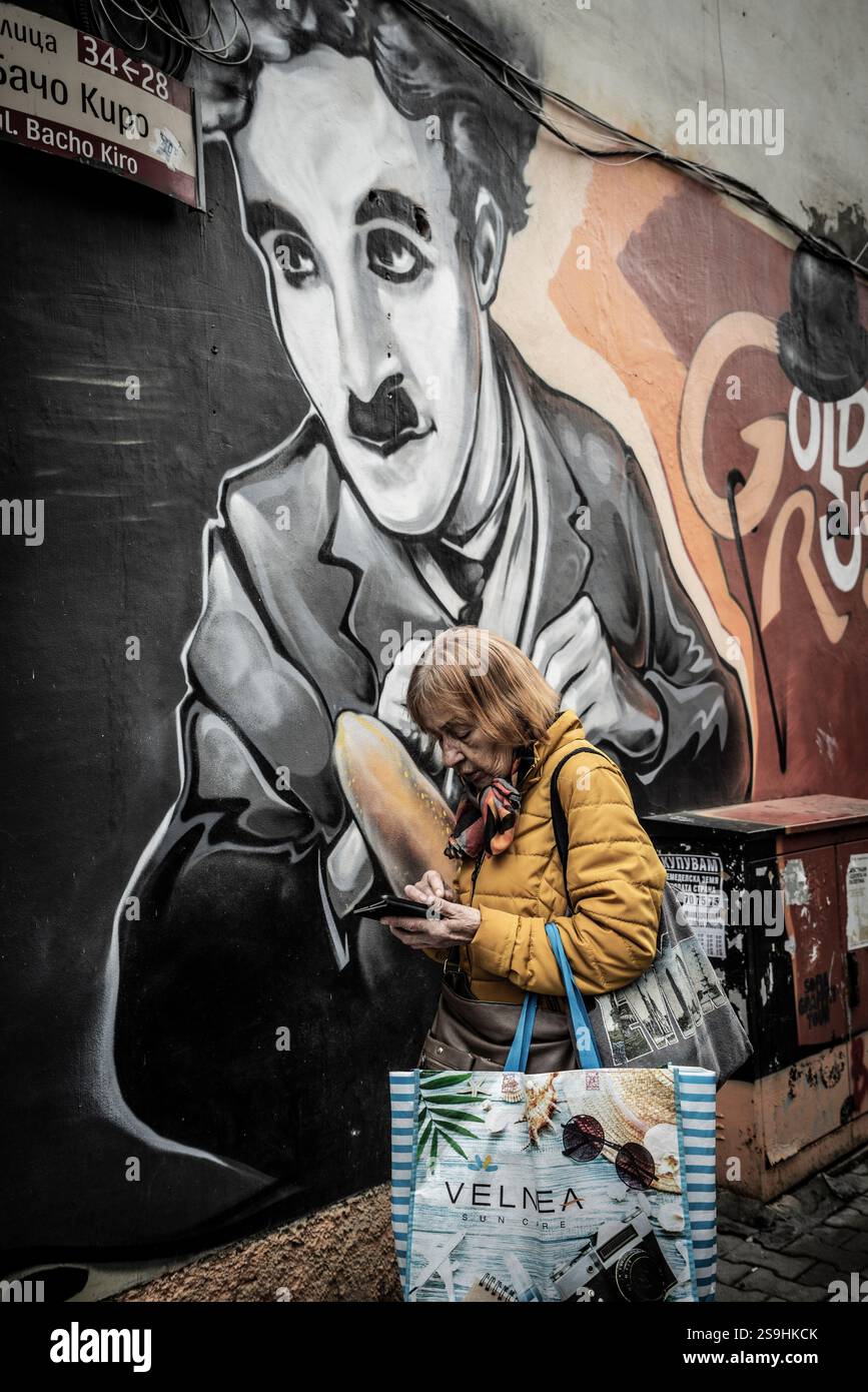 woman with a loaf of bread in front of Charlie Chaplin graffiti ...