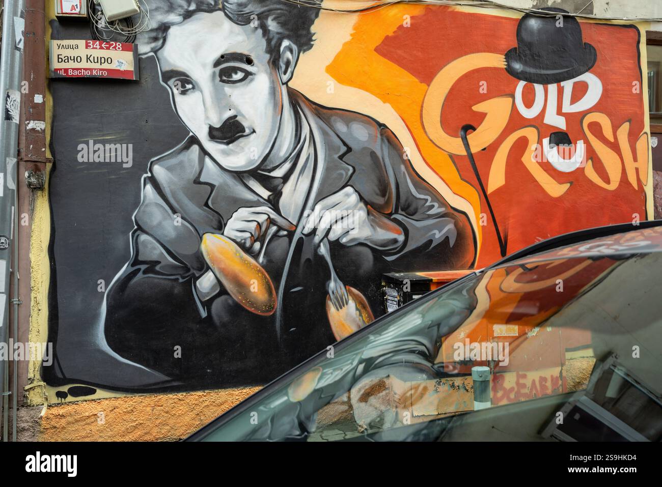 woman with a loaf of bread in front of Charlie Chaplin graffiti ...