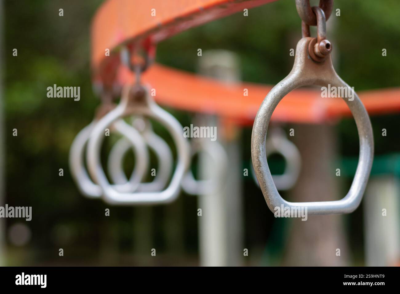 Silver metal monkey rings on an orange frame in a childrens playground ...