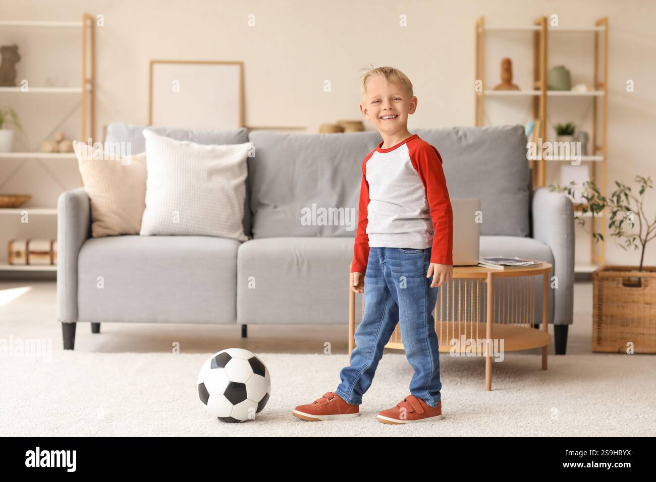 Cute little football player with soccer ball playing in room Stock ...