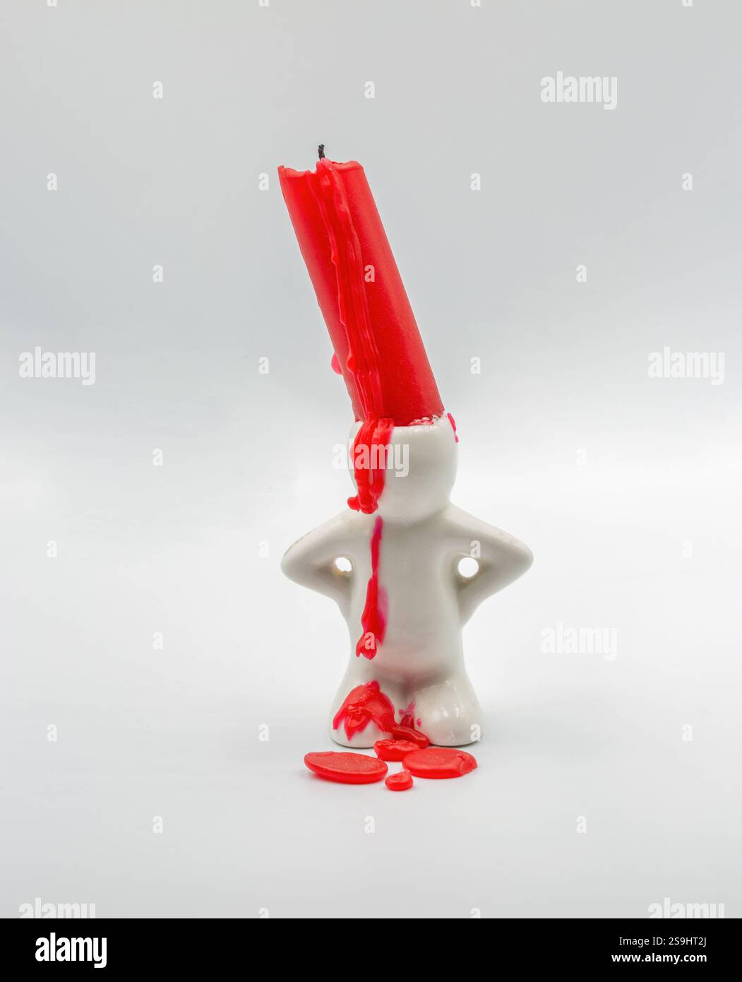 Red candle stub in cute candlestick in the shape of a man closeup on ...
