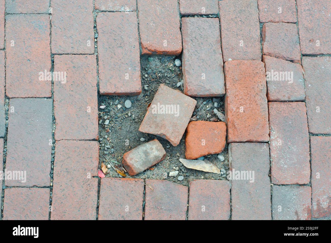 Close up overhead view of a section of a red brick street with a few ...