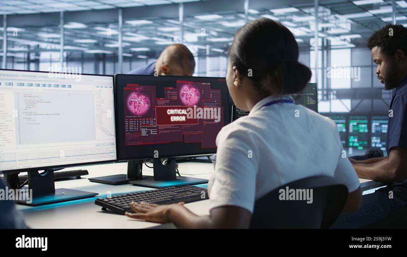 Woman seeing critical error on PC screen in data center, requesting help from cybersecurity team ...