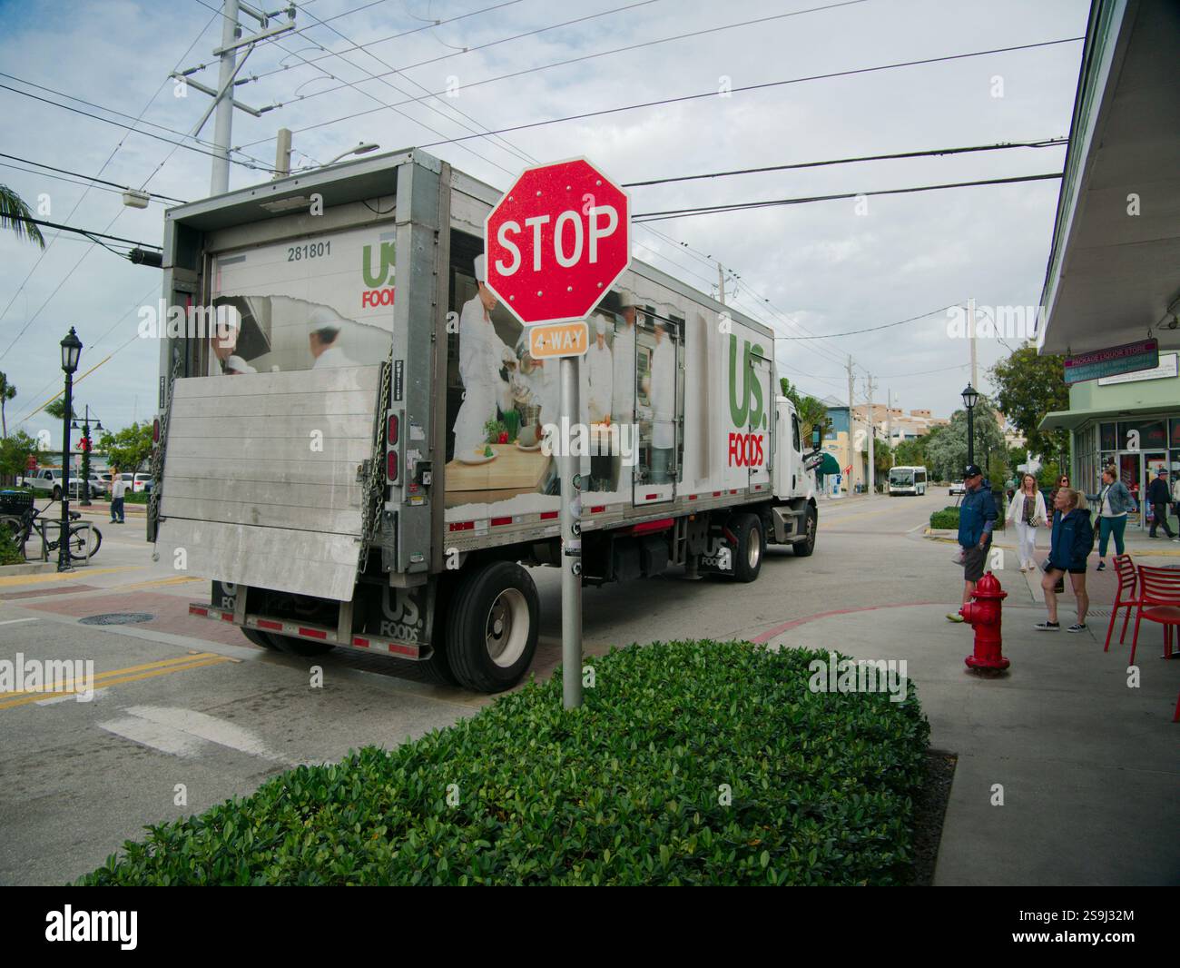Wide view US Foods semi truck delivery passing a stop sign on the ...