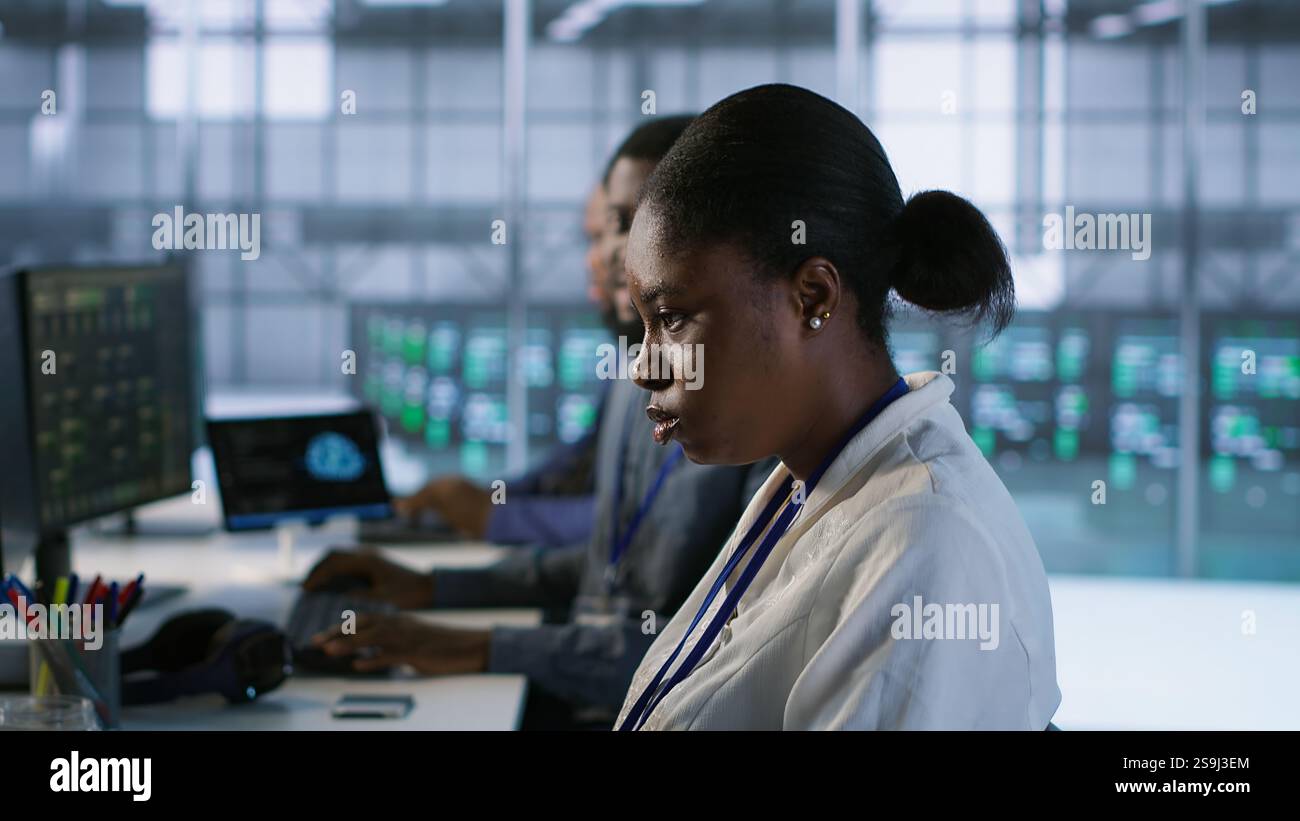 African american data center technicians implement AI predictive maintenance systems. Woman in ...