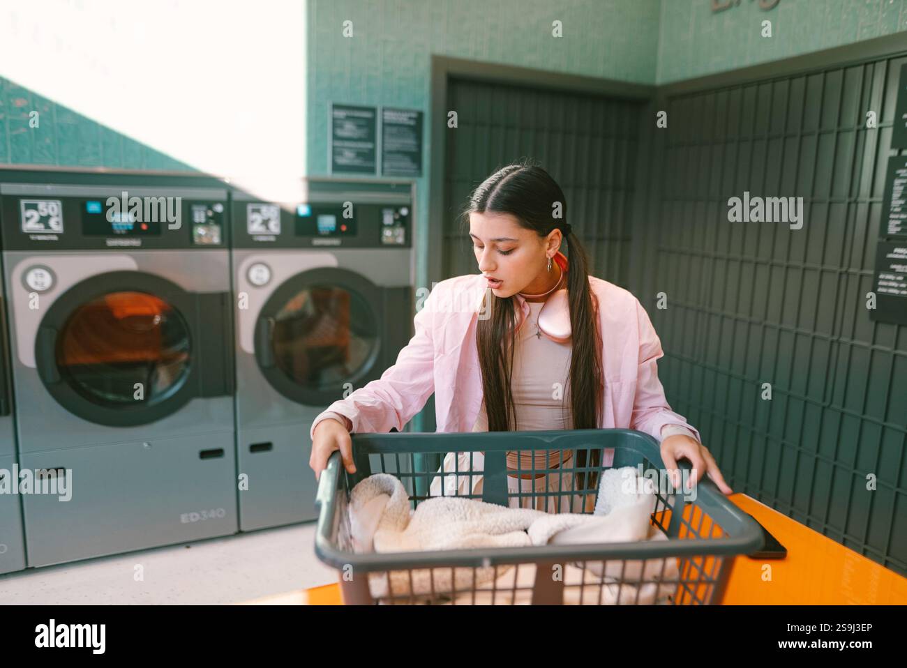 A Young Woman Happily Doing Laundry in a Bright and Modern Laundromat Environment Stock Photo ...