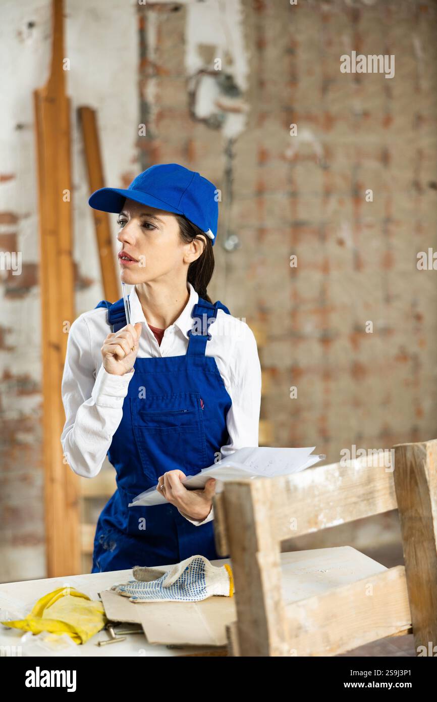 Female designer making checklist while planning building overhaul Stock ...
