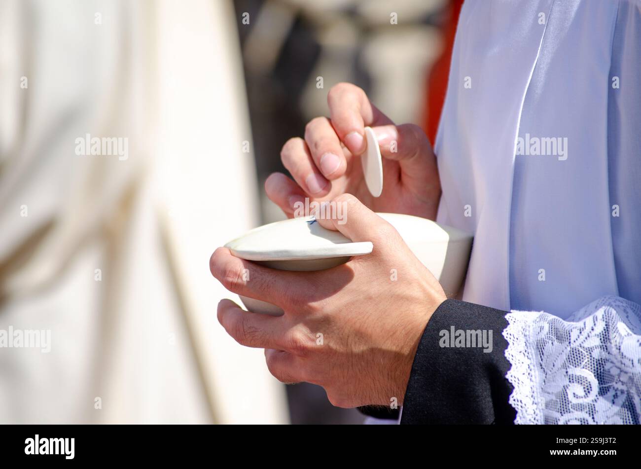 a priest holds the calix with the sacred form during the sacrament of ...