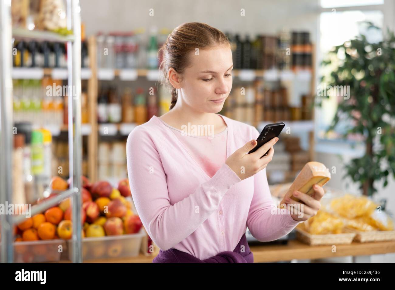 Female buyer scans QR code on cheese label in grocery store Stock Photo ...