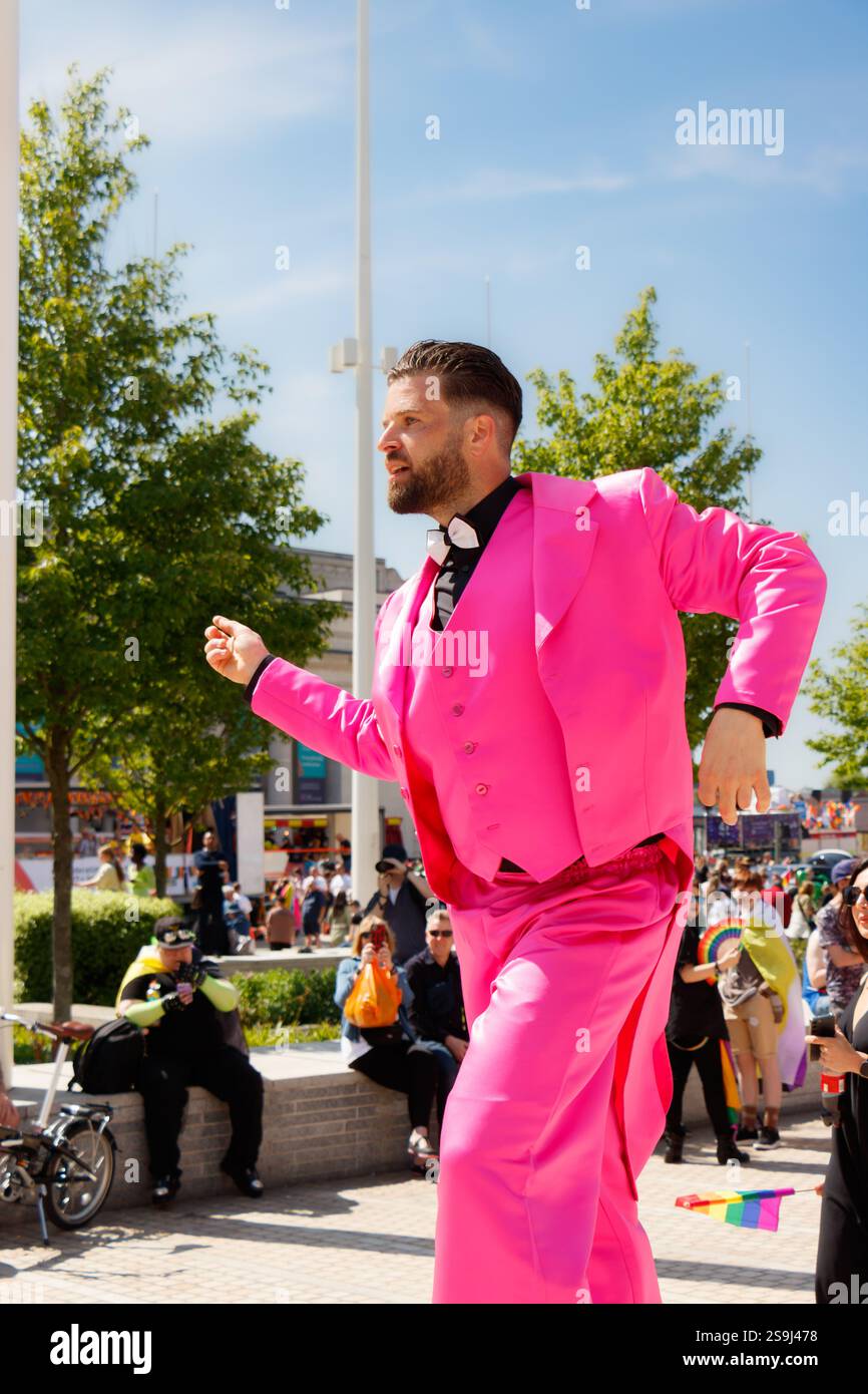 male performer in baggy pink satin suit at Birmingham Pride celebrating ...