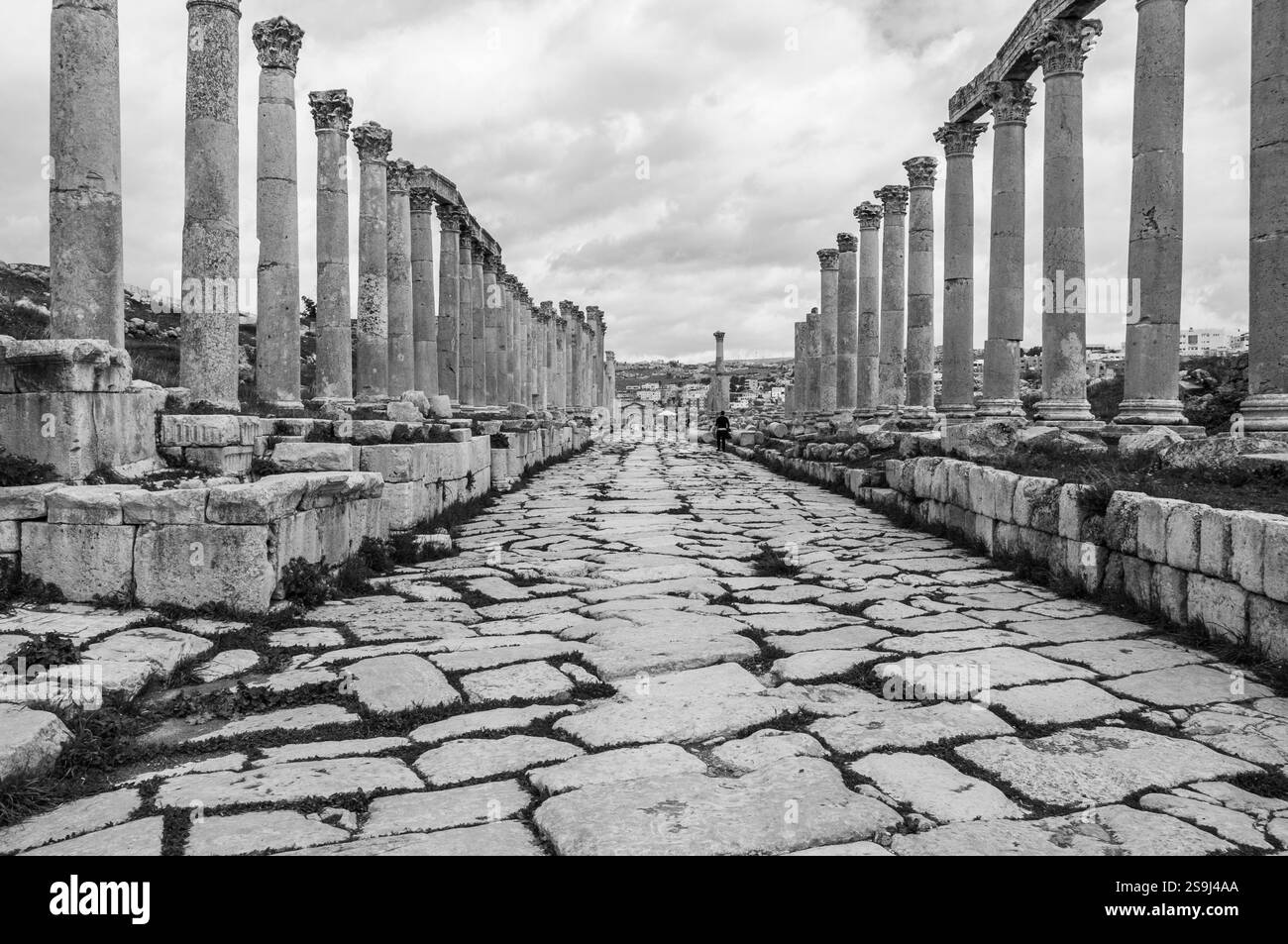 A long, narrow street with a lot of pillars. The pillars are old and ...