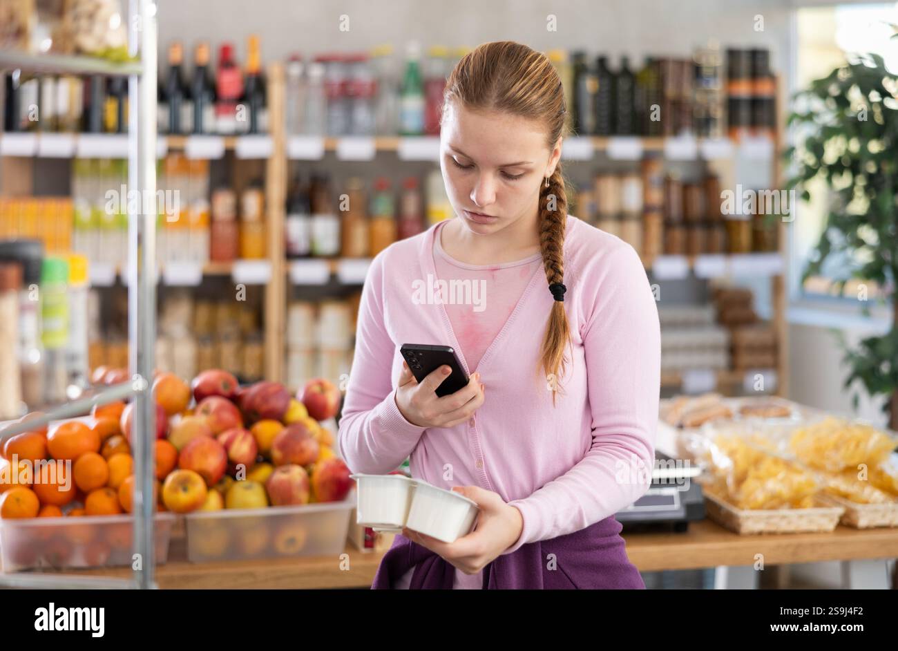 Checking expiration date of yogurt - female shopper scans QR code on ...