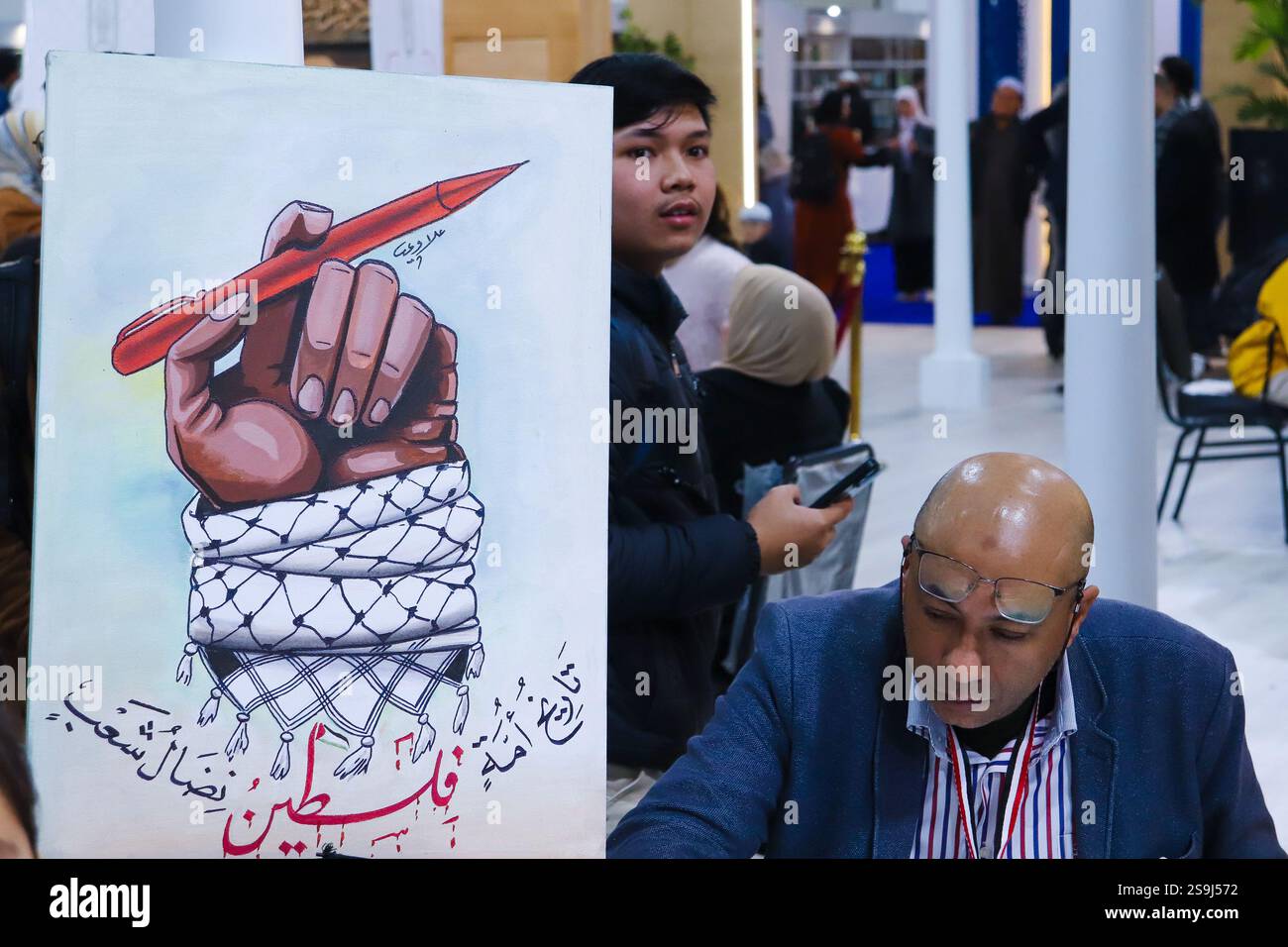 An artist draws slogans and drawings about Palestine at the 56th Cairo ...
