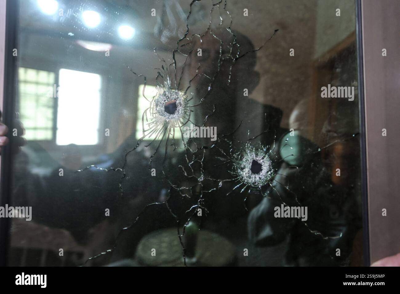 Jenin, Palestine. 26th Jan, 2025. A bullet-riddled window is seen in a ...