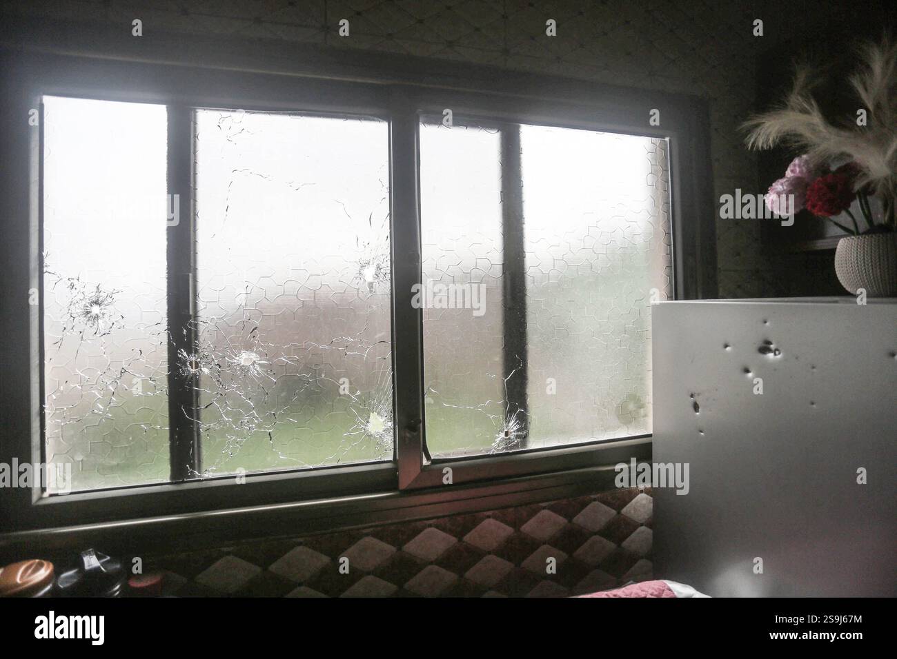A bullet-riddled window is seen in a room of two-and-a-half-year-old ...