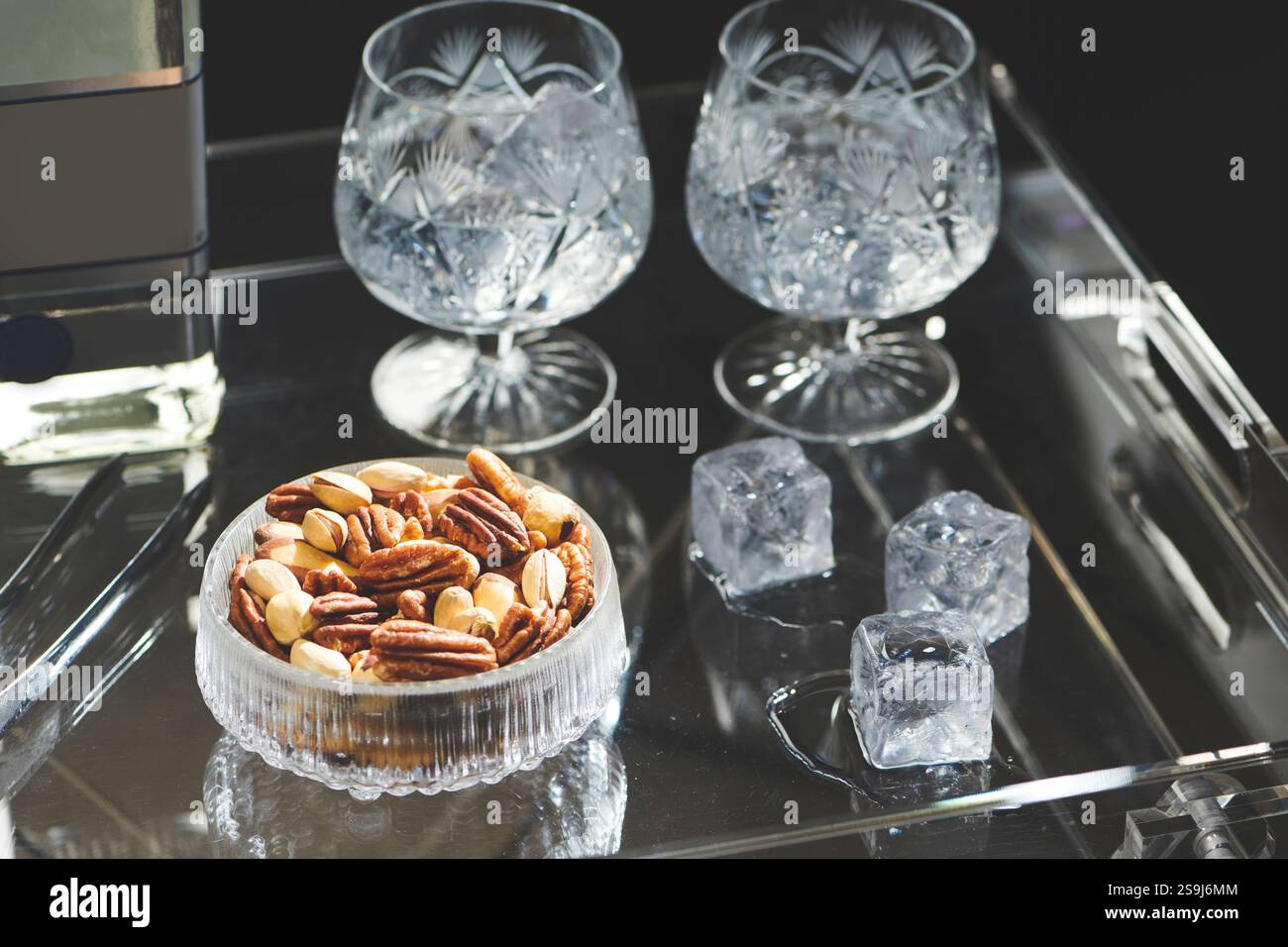 Mix Nuts in a Glass Bowl on a Glass Serving Tray with two Empty Glasses ...