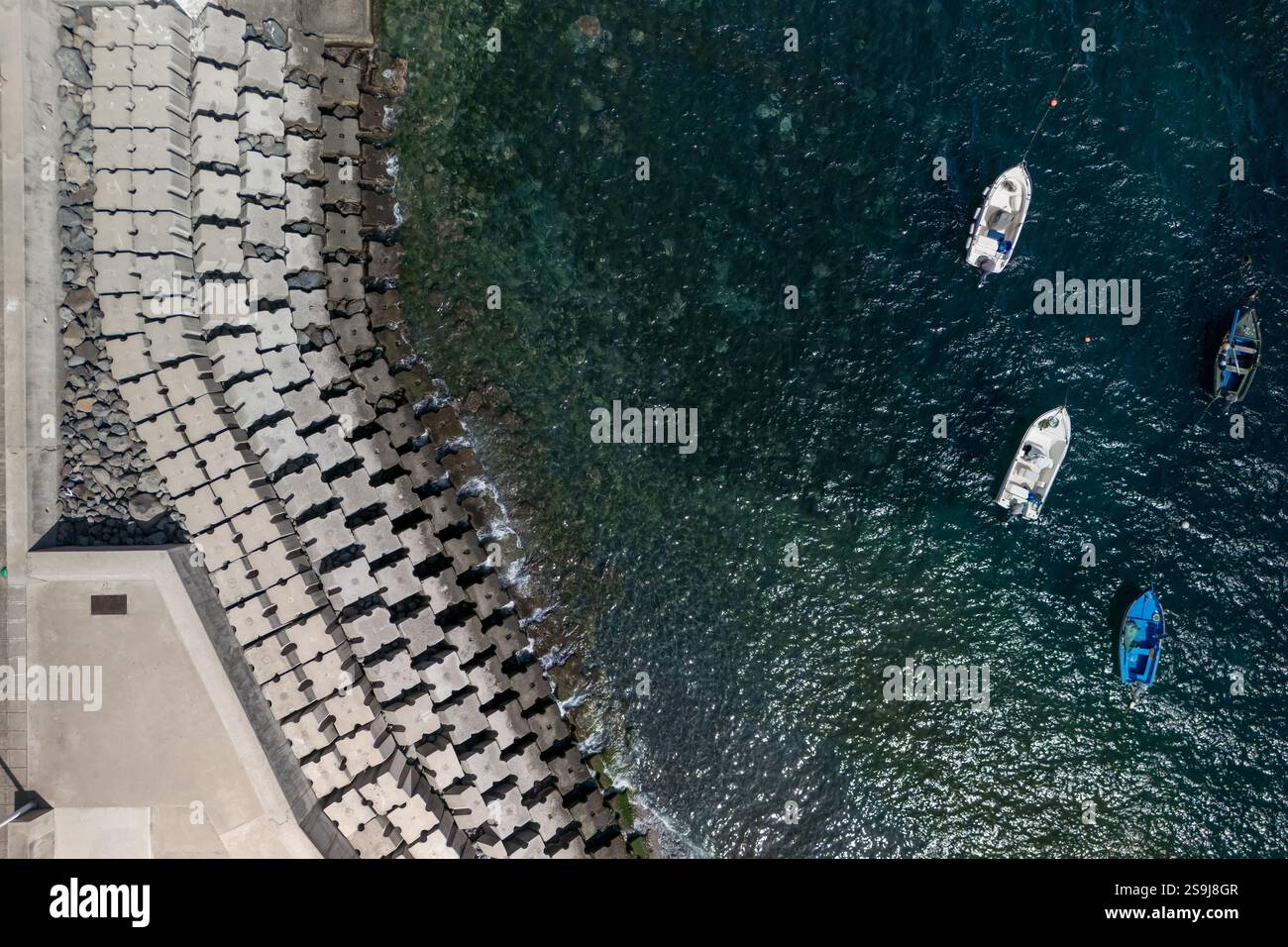 Top down view of concrete blocks sea barrier and boats in Portugal ...