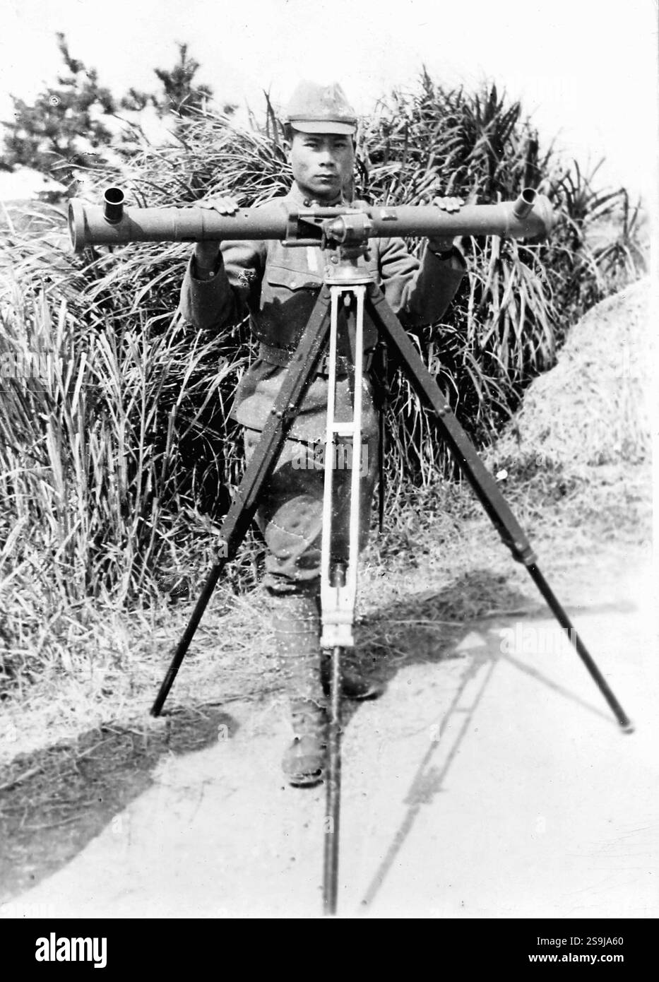 A Japanese officer stands with his sighting periscope type device ...