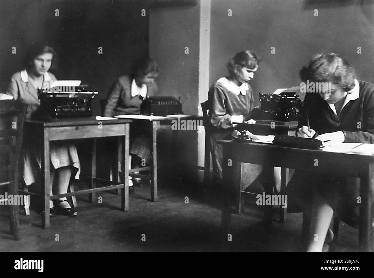 Young women work in the secretarial pool on their typewriters, ca. 1930 ...
