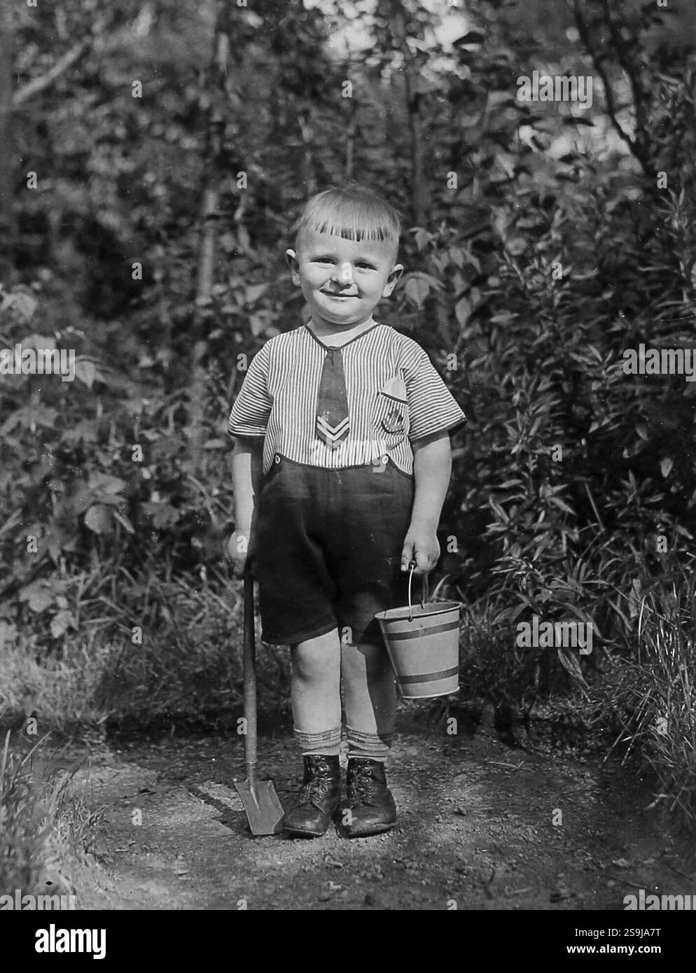 A portrait of young German boy with his pail and shovel toys, ca. 1930 ...