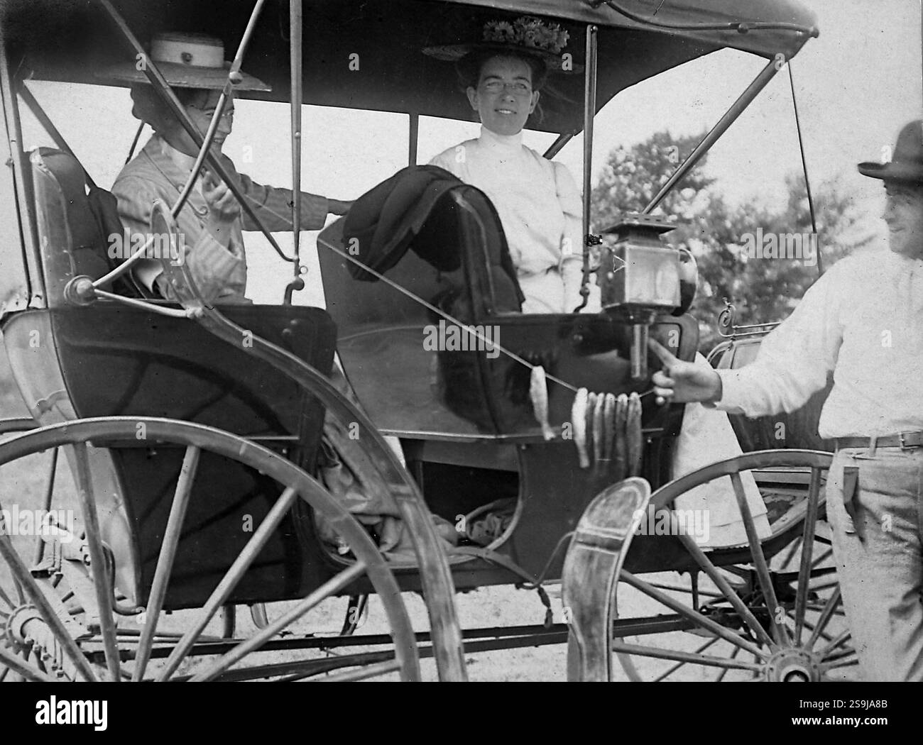 A trio shows off their fishing catch a stringer hanging from their ...