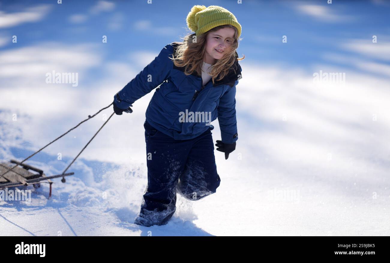 Kid boy play in the snow with a winter hat. Happy kid in warm clothes ...