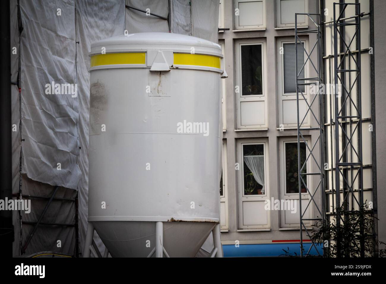 An industrial concrete mixer and silo dominate a construction site ...