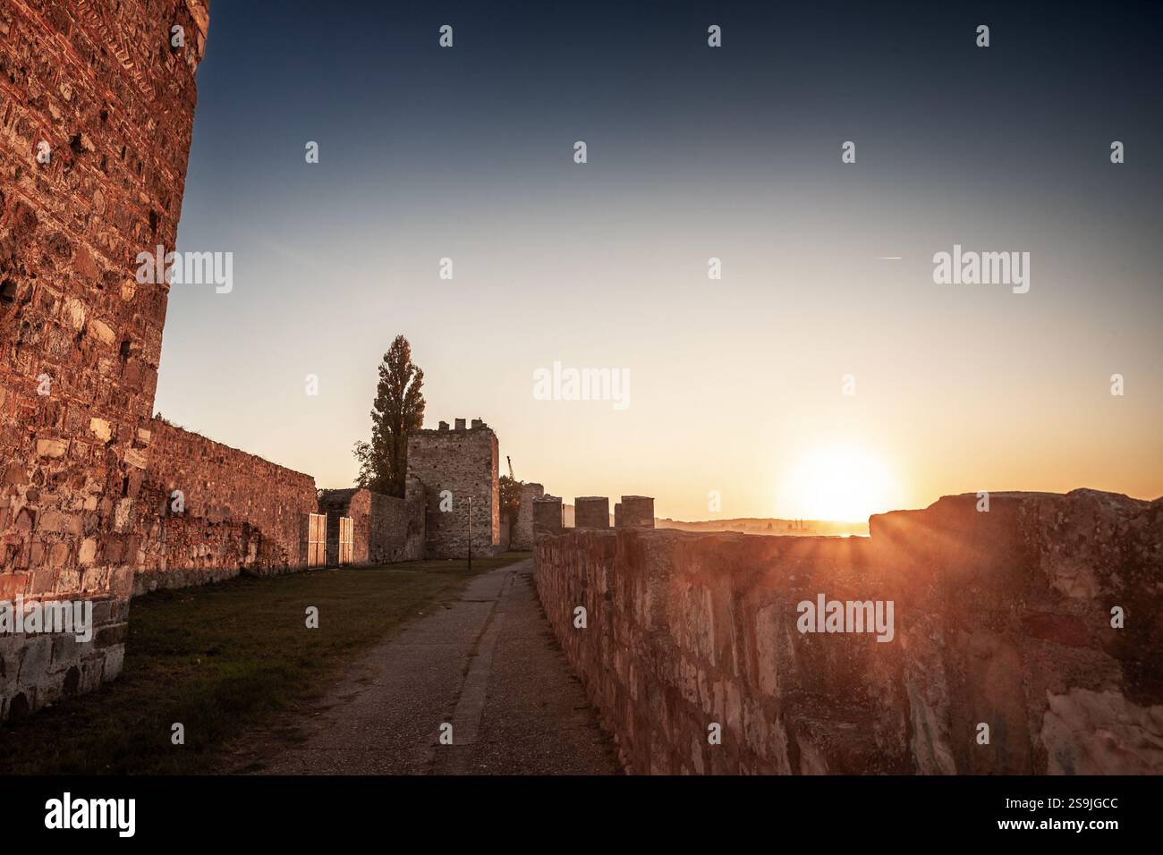 Stone walls of the medieval Smederevo Fortress glow in the sunset light ...