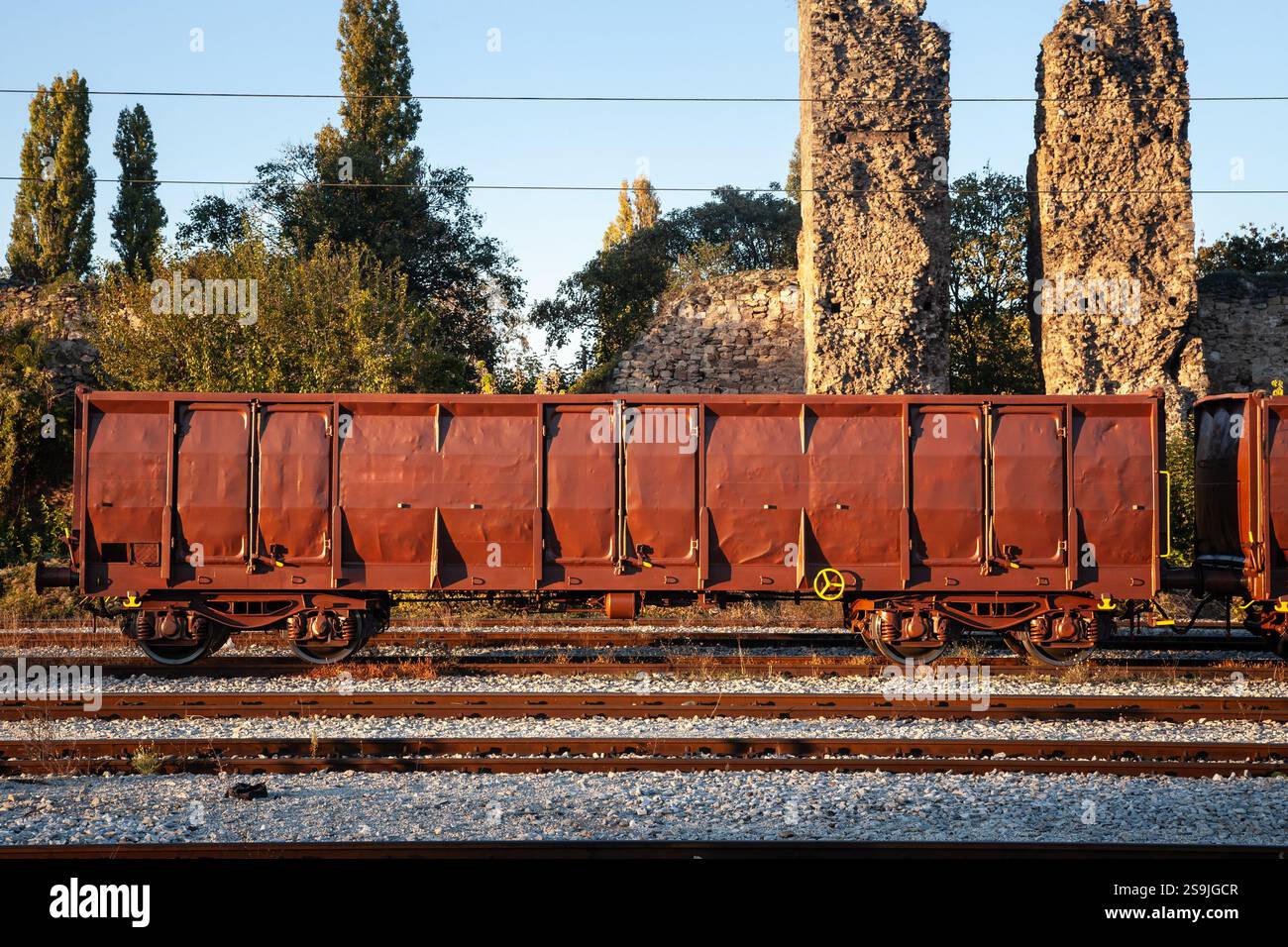 A brown gondola freight wagon (also called open car) stands on railway ...